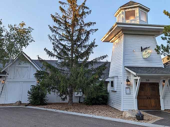 The charming exterior of Lola's Lakehouse welcomes you with classic lakeside architecture that promises great food and relaxing waterfront vibes ahead.