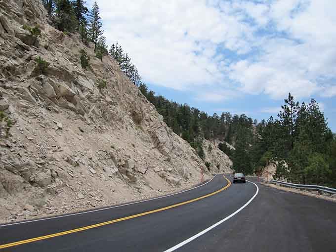 Guard rails protecting you from spectacular drops while framing views that belong on postcards, not highways.