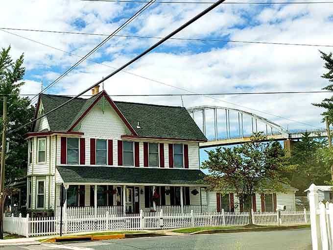 That white picket fence and red shutters combo hits different when there's a massive bridge photobombing your small-town charm.
