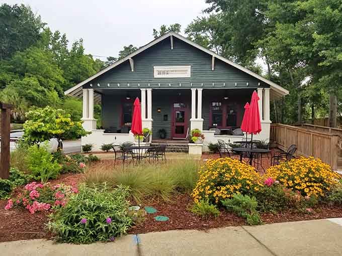 Red umbrellas and blooming gardens frame this craftsman house where books and beverages create the perfect partnership.
