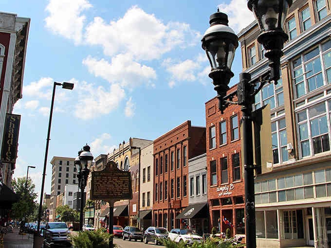 Those vintage lampposts and brick facades create a streetscape that feels like stepping into a friendlier, more charming era.