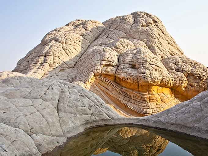 That rare desert pool creates a perfect mirror image, doubling your geological wonder and your Instagram likes simultaneously.