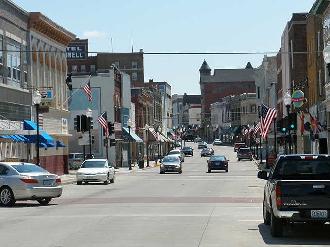 Main Street stretches ahead with flags flying and historic buildings standing proud, inviting you to park and explore on foot.