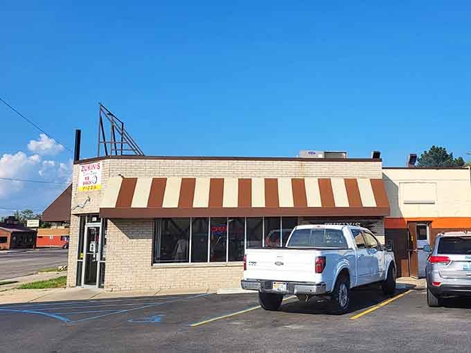 That striped awning and vintage sign tell you everything: this place has been perfecting comfort food since your bell-bottoms were cool.