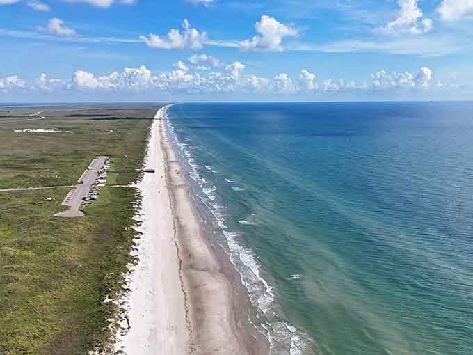 This aerial view shows just how beautifully undeveloped Malaquite Beach remains, with natural dunes protecting the pristine shoreline beyond.