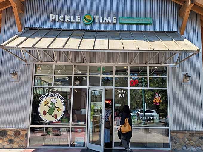 That cheerful pickle mascot in the window isn't just decoration, it's a promise of delicious absurdity inside.