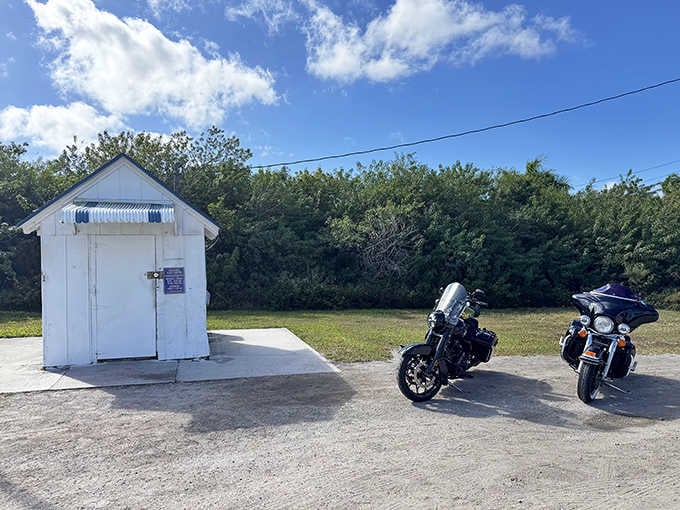 Two motorcycles dwarf the building, making this postal outpost look like it belongs in a dollhouse.