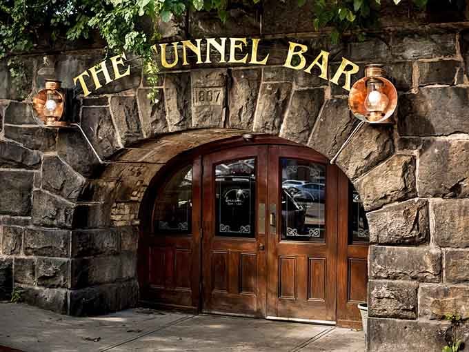 Those copper lanterns flanking the stone archway aren't just for show, they're your beacon to underground cocktail paradise.