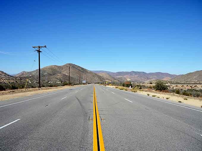 Smooth pavement ribbons through rugged terrain, proving California's got more layers than your favorite lasagna.