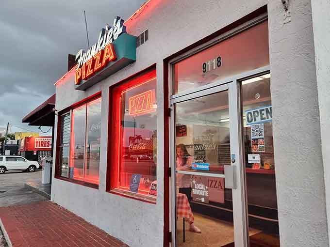 That vintage signage glowing in neon isn't just decoration, it's a beacon calling pizza lovers home for seven decades.