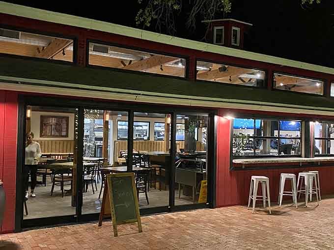 That classic red barn exterior glows like a beacon promising comfort food and cold beer inside.