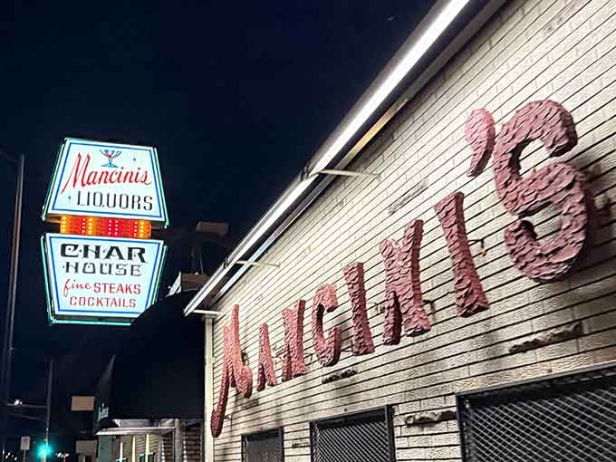 That glowing sign at night promises exactly what it delivers: perfectly charbroiled steaks and serious cocktails.