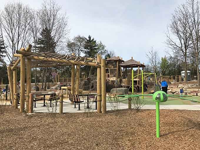 Natural wood structures blend seamlessly with the surrounding trees, creating a playground that feels like part of the forest itself.