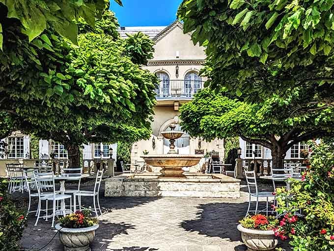 The elegant courtyard fountain provides a tranquil centerpiece surrounded by vine-covered walls, perfect for savoring wine on a sunny afternoon.