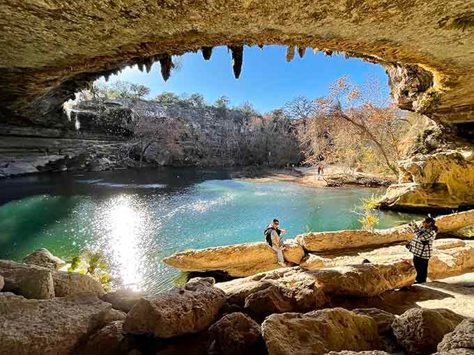 Nature's cathedral features stalactites hanging like ancient chandeliers above jade waters that'll make you forget chlorinated pools exist.