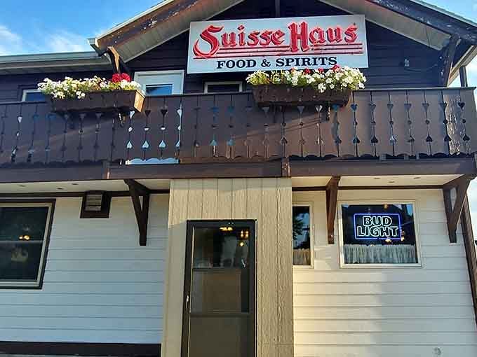 That chalet-style balcony and glowing neon sign say everything: warmth, cold drinks, and something delicious waiting inside.