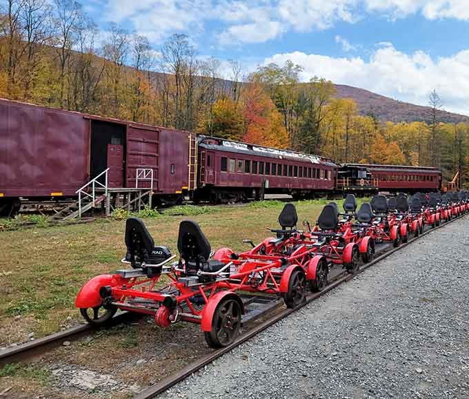 Those cherry-red rail bikes lined up against vintage train cars and autumn mountains look like pure adventure waiting to happen.