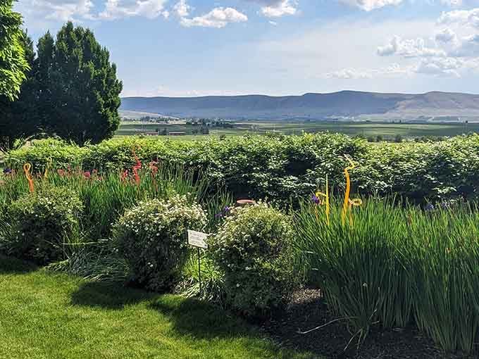 The beautifully landscaped gardens frame stunning views of Red Mountain and the surrounding vineyards stretching toward the distant hills beyond.