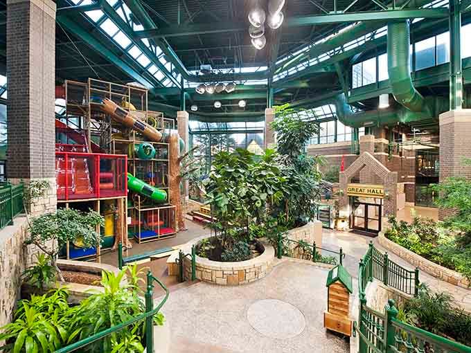 Natural light floods through the glass ceiling, illuminating the tropical paradise that awaits families seeking winter escape and adventure.