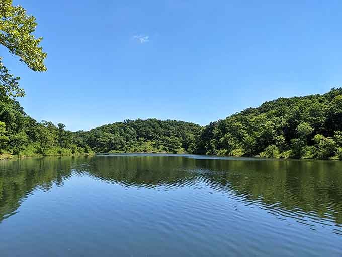 Mirror-smooth water reflecting endless green hills, this lake view looks like nature's own screensaver come to life.