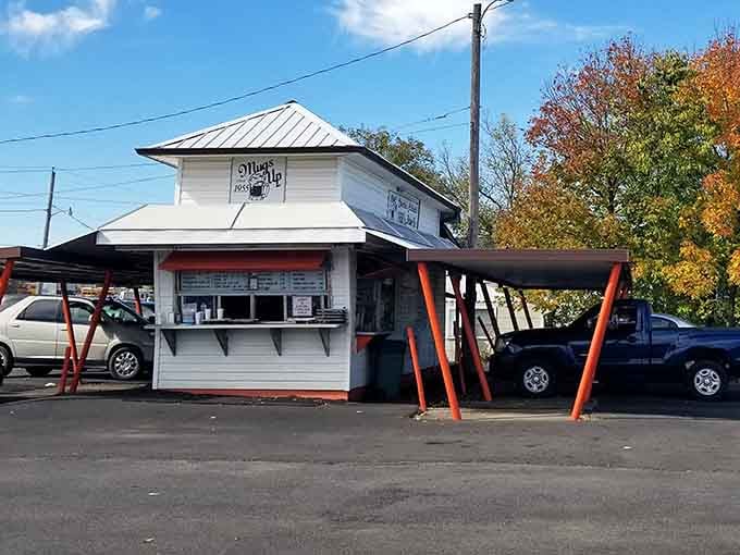 Those red support beams frame the ordering windows like a stage, where the real show is watching your chili cheese fries being made.