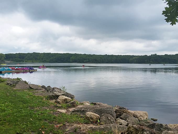 Pierce Lake stretches out like glass under moody skies, where colorful paddleboats wait patiently for summer adventurers.