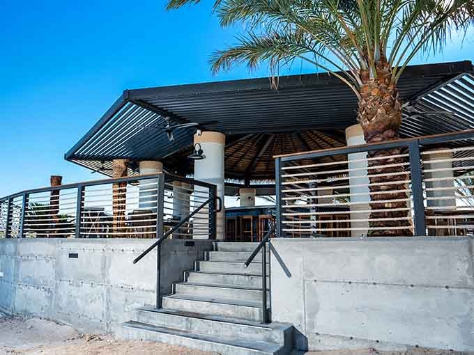 Modern meets tropical at this lakeside oasis where concrete steps lead to pure vacation vibes.