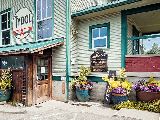 That cheerful exterior with its flower pots is basically screaming "come get carbs and happiness" in the most delightful way.