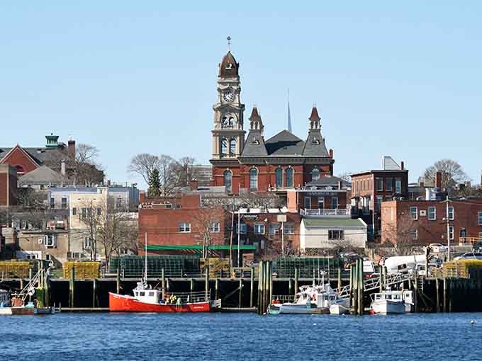 The working harbor brings Gloucester's fishing heritage to life, with colorful boats docked against the backdrop of the town's iconic buildings.