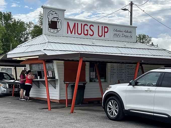 That classic red and white sign under blue skies tells you everything: authentic drive-in magic awaits below.