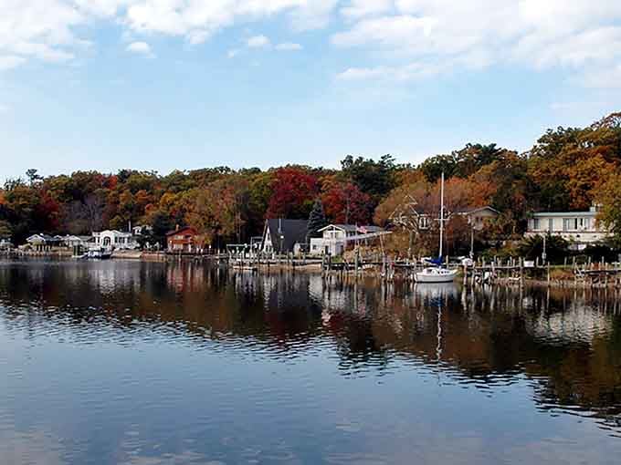 Fall foliage frames the harbor like nature's own postcard, proving Michigan does autumn better than your leaf-peeping relatives out East.