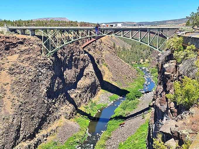 Dark volcanic walls frame the emerald river below, proving nature's color palette beats any artist's wildest imagination.