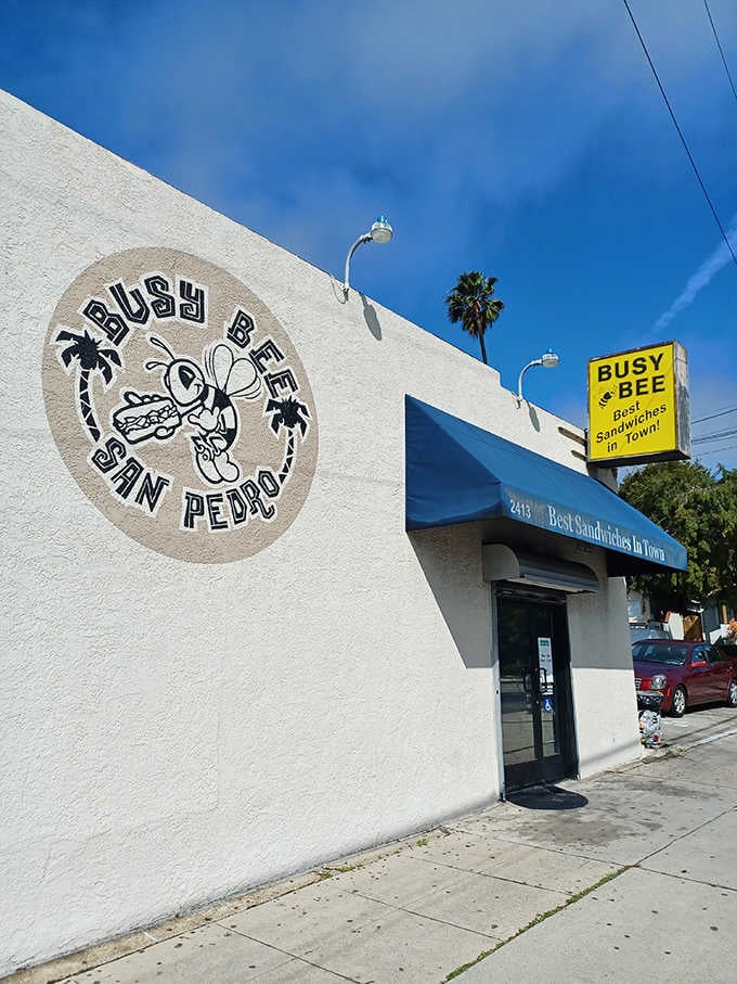 The weathered yellow sign stands tall like a lighthouse guiding sandwich seekers to their delicious destination.