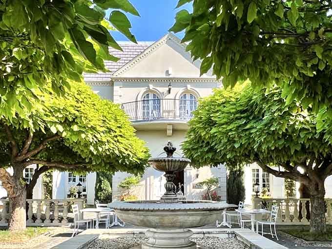 The elegant courtyard fountain provides a tranquil centerpiece surrounded by vine-covered walls, perfect for savoring wine on a sunny afternoon.