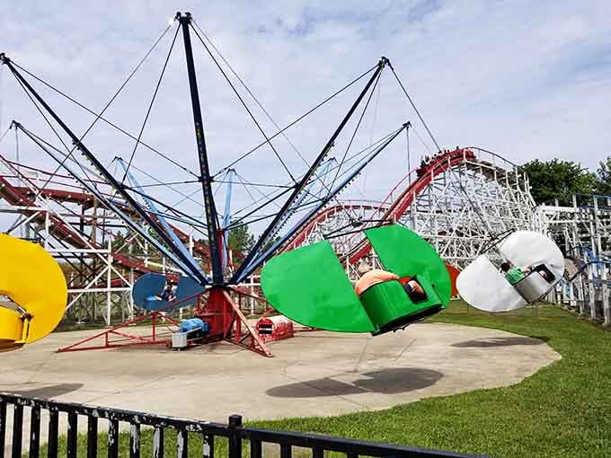 Bright carnival colors pop against white clouds as this spinning ride prepares to send happy screams skyward.