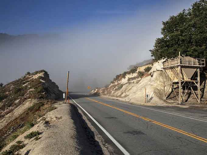 Fog rolls across the asphalt like a movie effect, adding mystery to an already dramatic landscape.