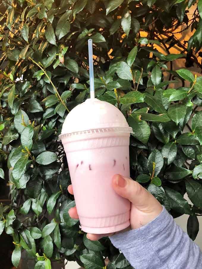 Pink Italian soda against green leaves: Instagram-worthy refreshment that actually tastes as good as it photographs.
