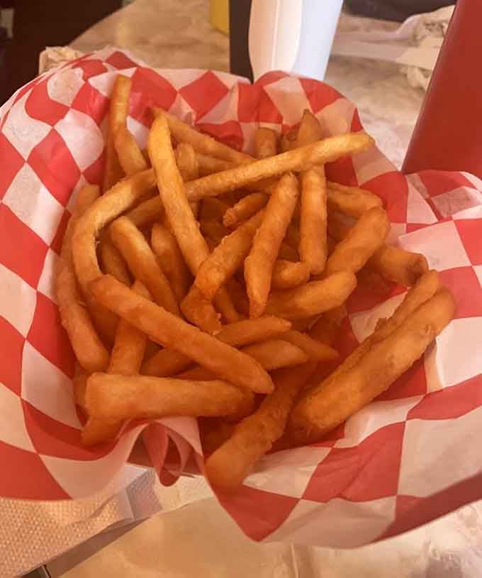 A mountain of perfectly golden fries in a checkered basket, proving simplicity is often the ultimate sophistication.