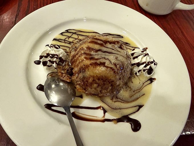 Bread pudding drizzled with sauce and topped with whipped cream, because subtlety is overrated when dessert's involved.