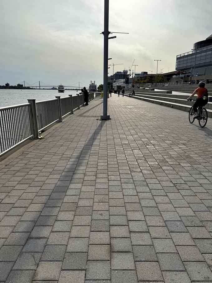 Cyclists cruise past on perfectly maintained paths where Detroit's industrial past meets its recreational present beautifully.