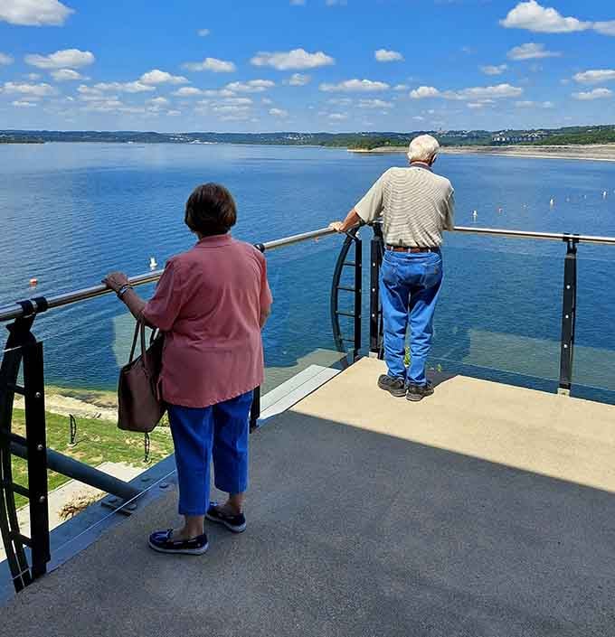 Two generations share a quiet moment watching boats glide across water that wasn't here seventy years ago.