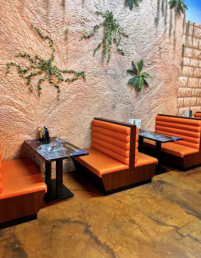 Orange booth seating against textured walls that transport you somewhere between Bedrock and fine dining excellence.