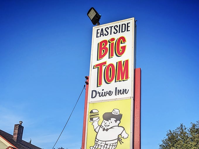 The Eastside Big Tom Drive Inn sign standing tall against a perfect blue sky, proud and unapologetic.