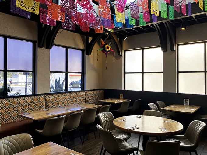 Natural light streaming through tall windows illuminates a dining room designed for comfort and conversation over multiple courses.