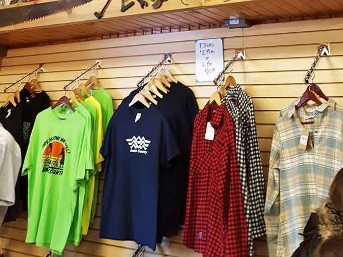 Local apparel hangs alongside flannel shirts, blending community pride with timeless country store style perfectly.