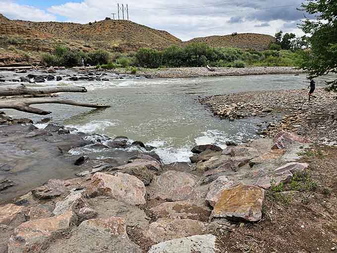 The Arkansas River flows past rocky banks where locals know the best fishing spots their grandfathers taught them decades ago.