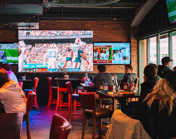Exposed ductwork and massive screens give the space an industrial-meets-entertainment vibe that somehow works perfectly for sports viewing.