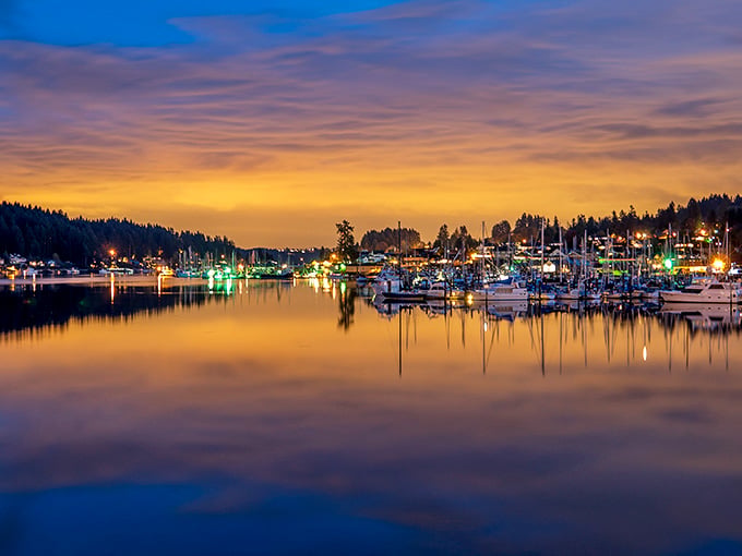 Harbor lights reflect on glassy water at dusk, creating a scene that professional photographers dream about nightly.
