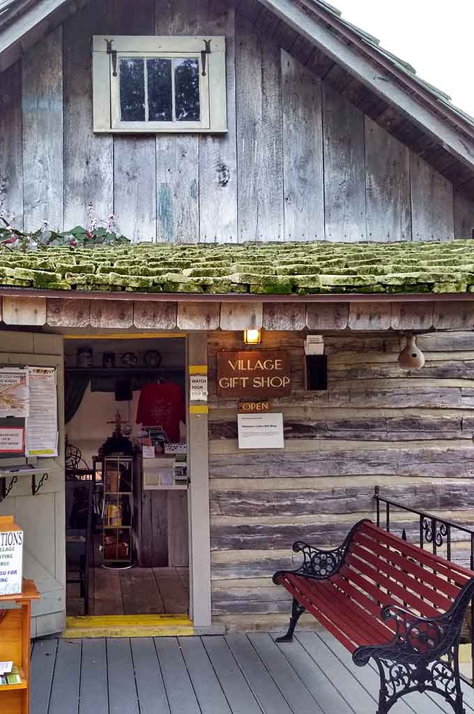 Moss-covered logs and a welcoming bench invite you to browse treasures where shopping meant actual human conversation.