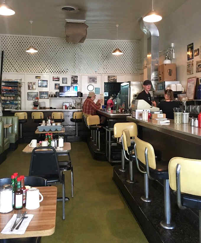 Yellow counter stools and vintage pendant lights create that timeless diner aesthetic we all secretly crave.